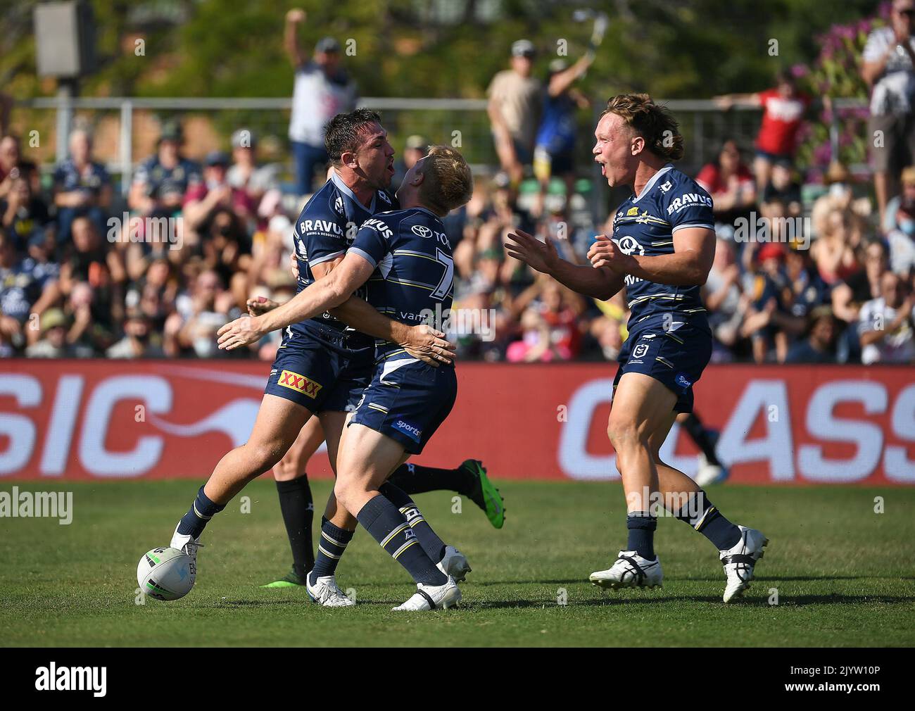 Reece Robson of the Cowboys (left) reacts after scoring a try during ...