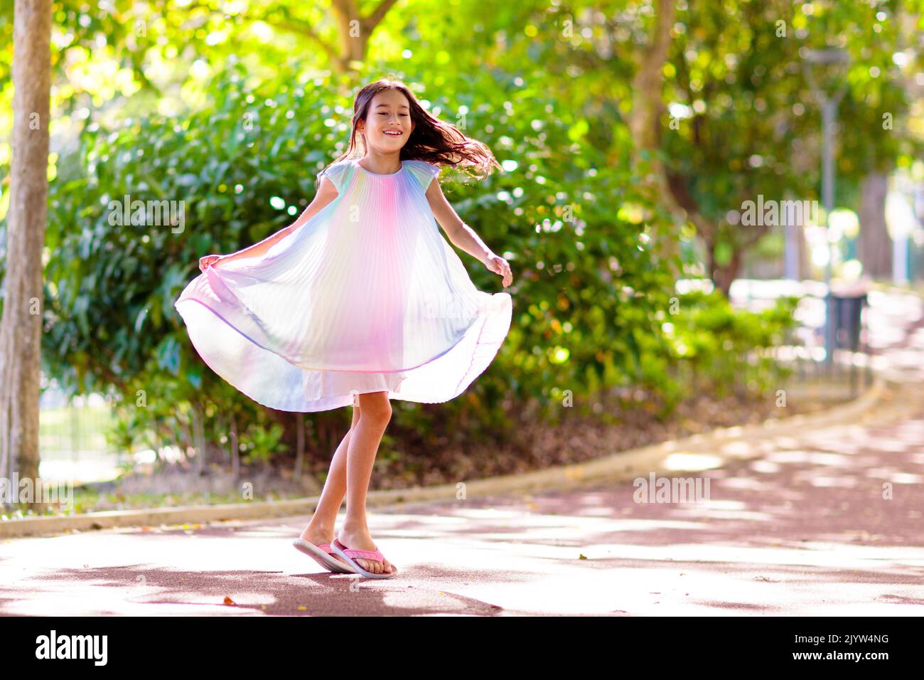 Happy kid playing in summer park. Little girl dancing in beautiful ...