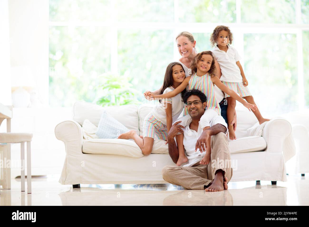 Happy family with kids at home. Parents and children sitting on white ...