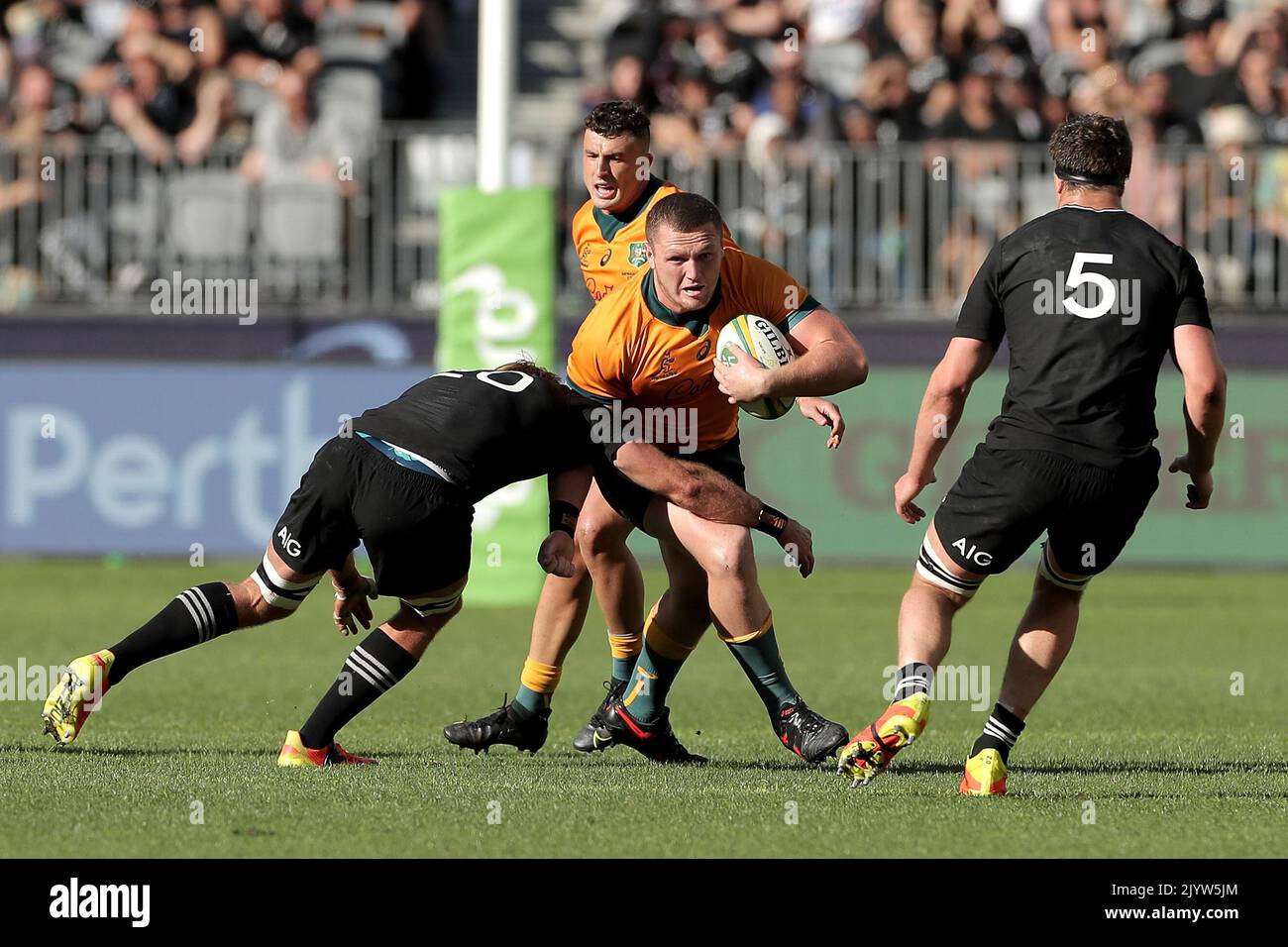 Angus Bell of the Wallabies is tackled by Ethan Blackadder of the All ...