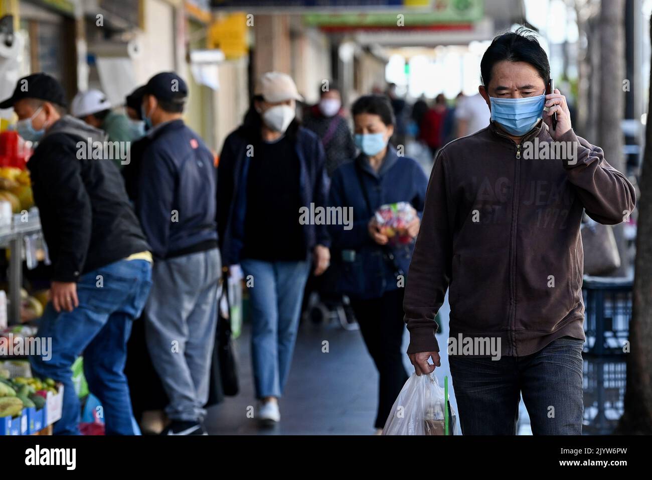 Members of the public wear face masks as they go about their daily ...