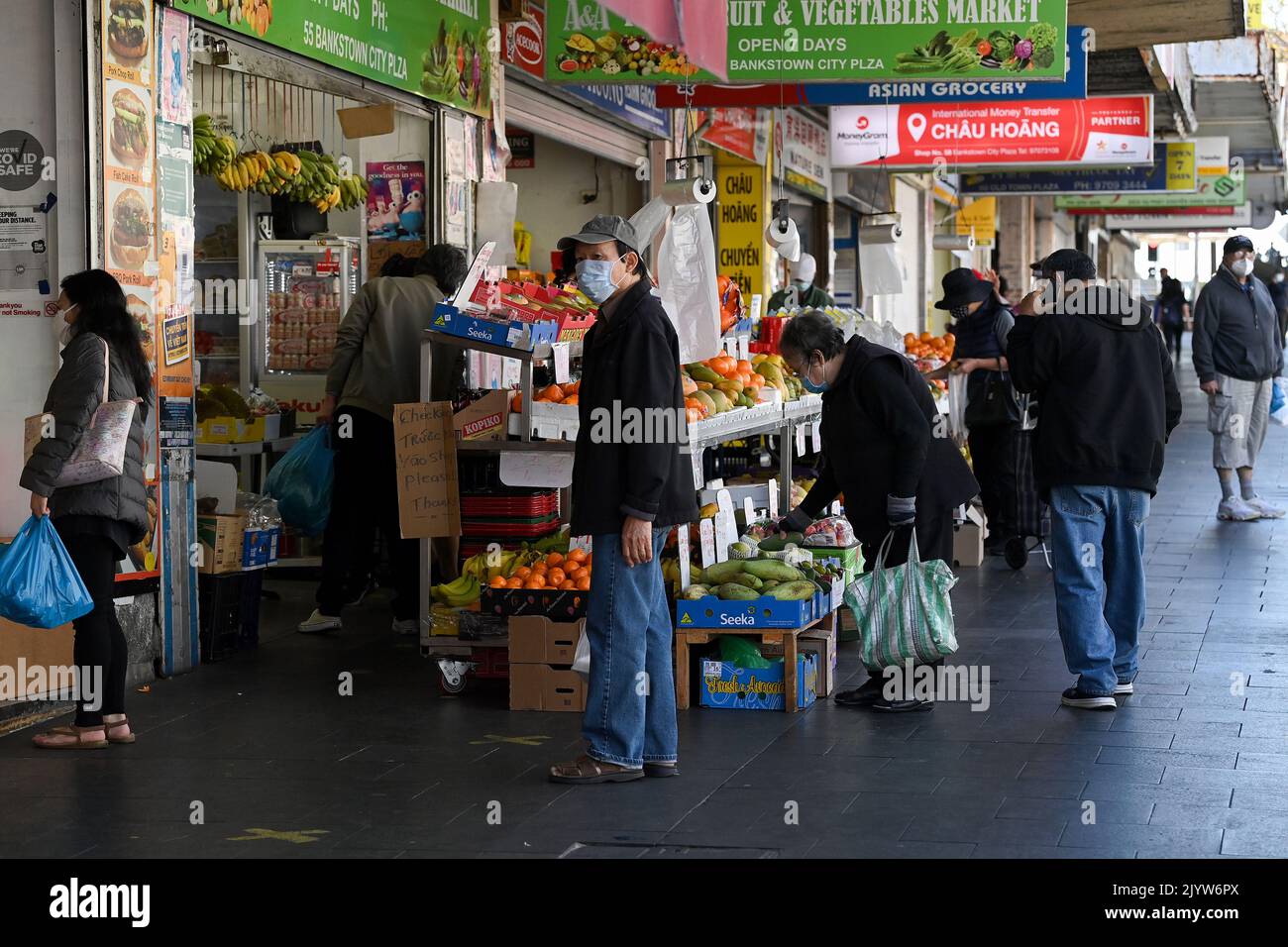 Members of the public wear face masks as they go about their daily ...