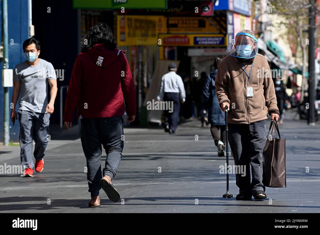 Members of the public wear face masks as they go about their daily ...