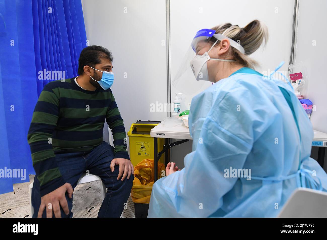 Asif Javed (left) speaks to a healthcare worker prior to receiving his ...