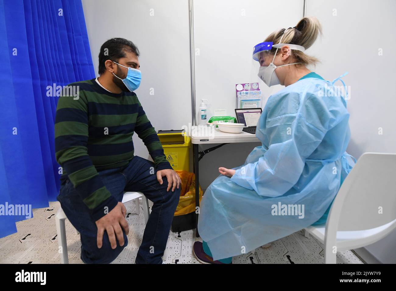 Asif Javed (left) speaks to a healthcare worker prior to receiving his ...