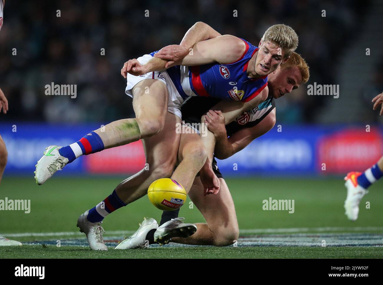 Tim English of the Bulldogs is tackled by Willem Drew of the Power ...