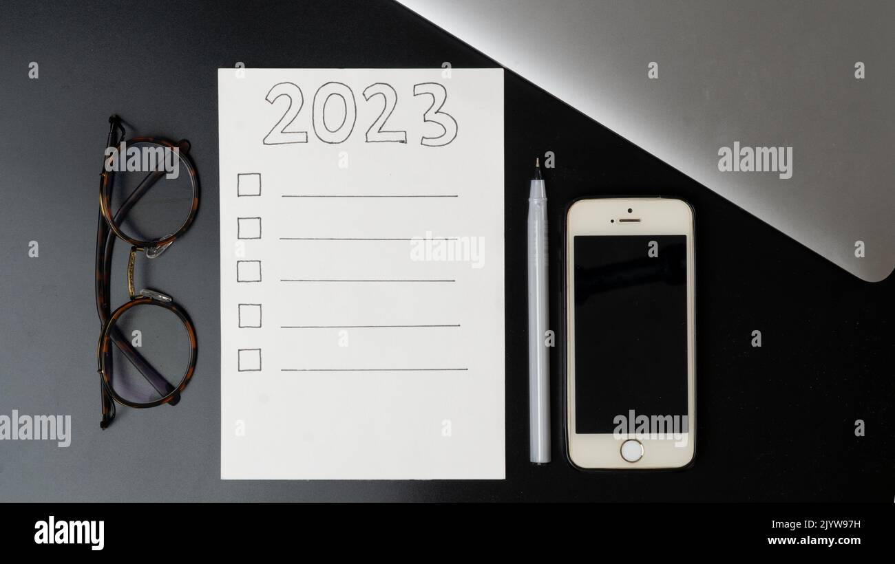 Plan things for the new year 2023, a blank checklist, glasses, phone ...