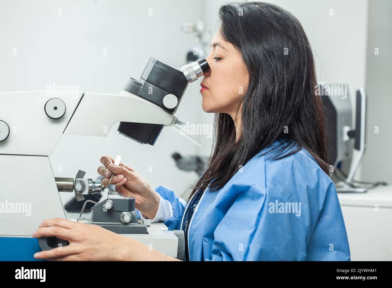 Female scientist placing a sample on a transmission electron microscopy ...