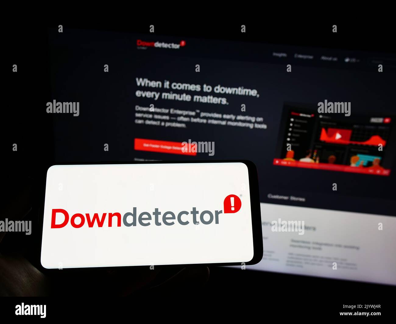 Person holding smartphone with logo of online platform Downdetector ...