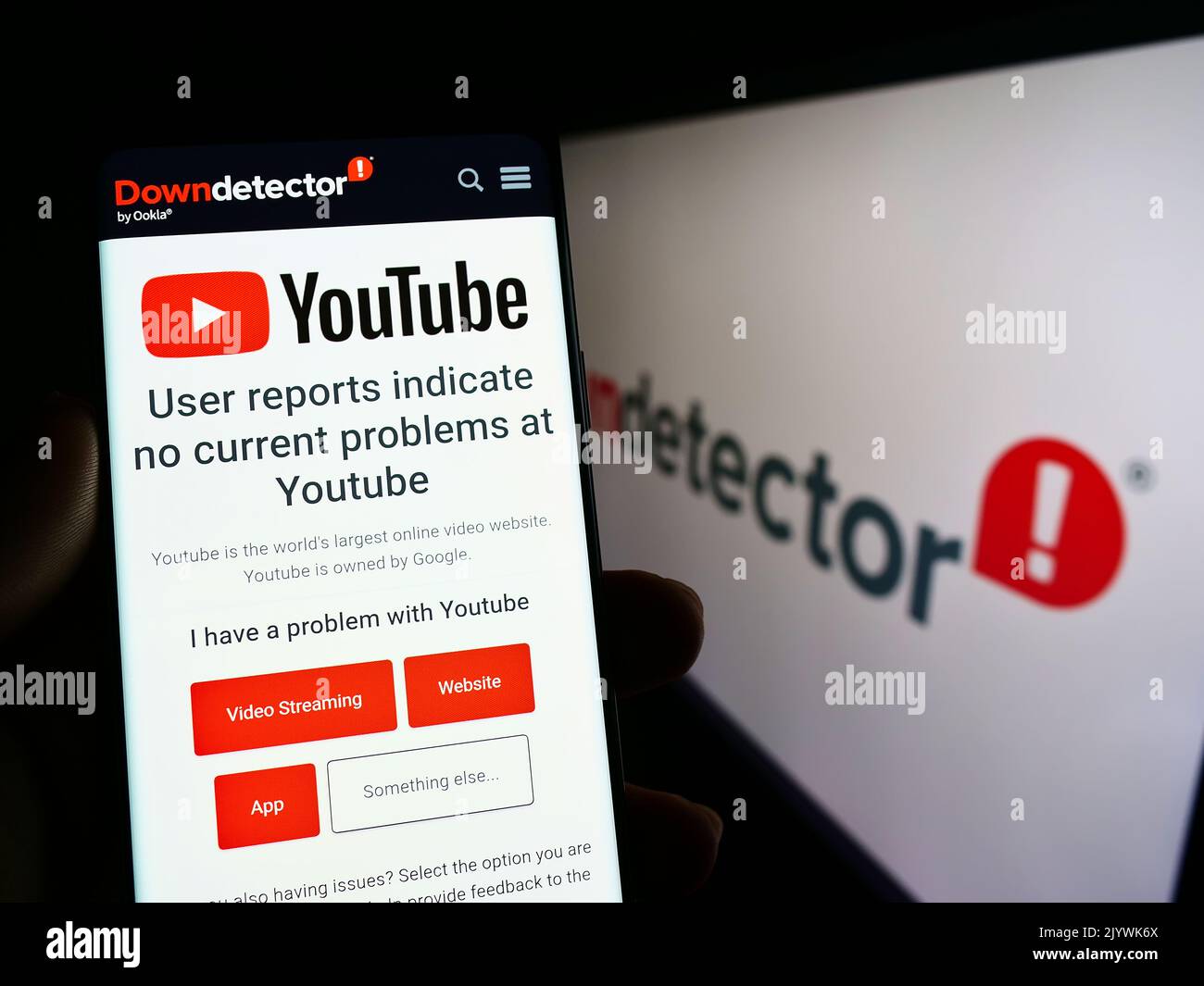 Person holding smartphone with website of platform Downdetector and ...