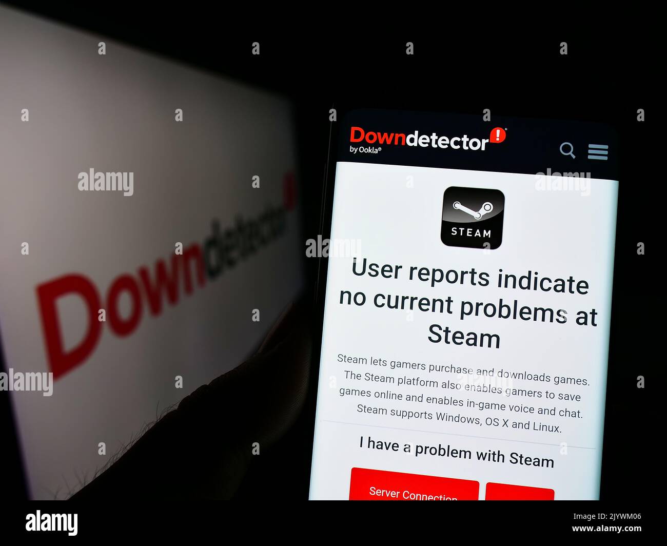 Person holding smartphone with website of platform Downdetector and ...