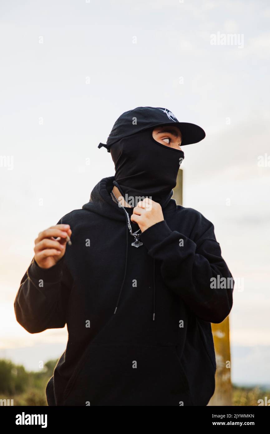 Guy with balaclava smoking a joint of marijuana outdoors Stock Photo ...