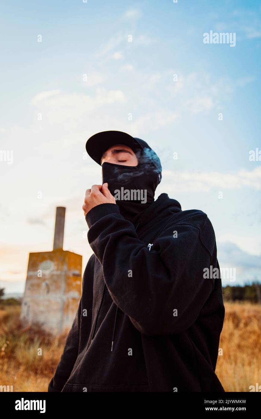 Guy with balaclava smoking a joint of marijuana outdoors Stock Photo ...