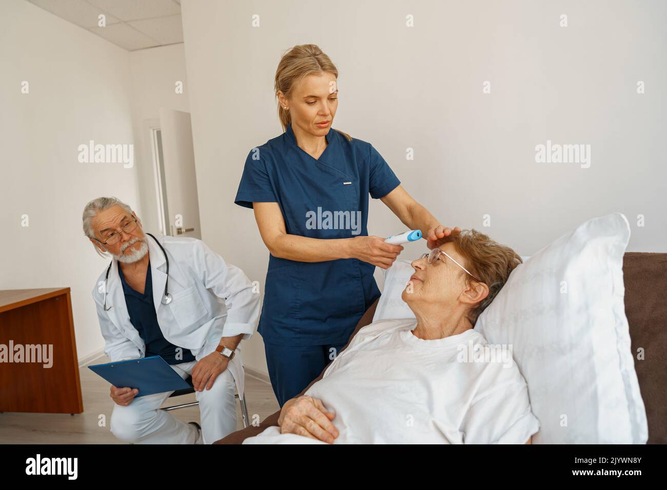 Doctor measures patient's temperature with non-contact thermometer in ...