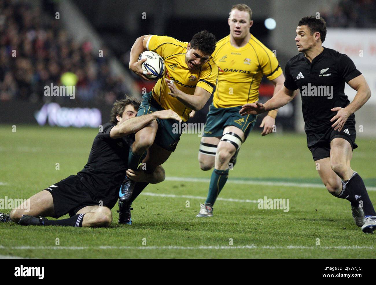 Australia's Anthony Faingaa (centre) is tackled by New Zealand's Conrad ...