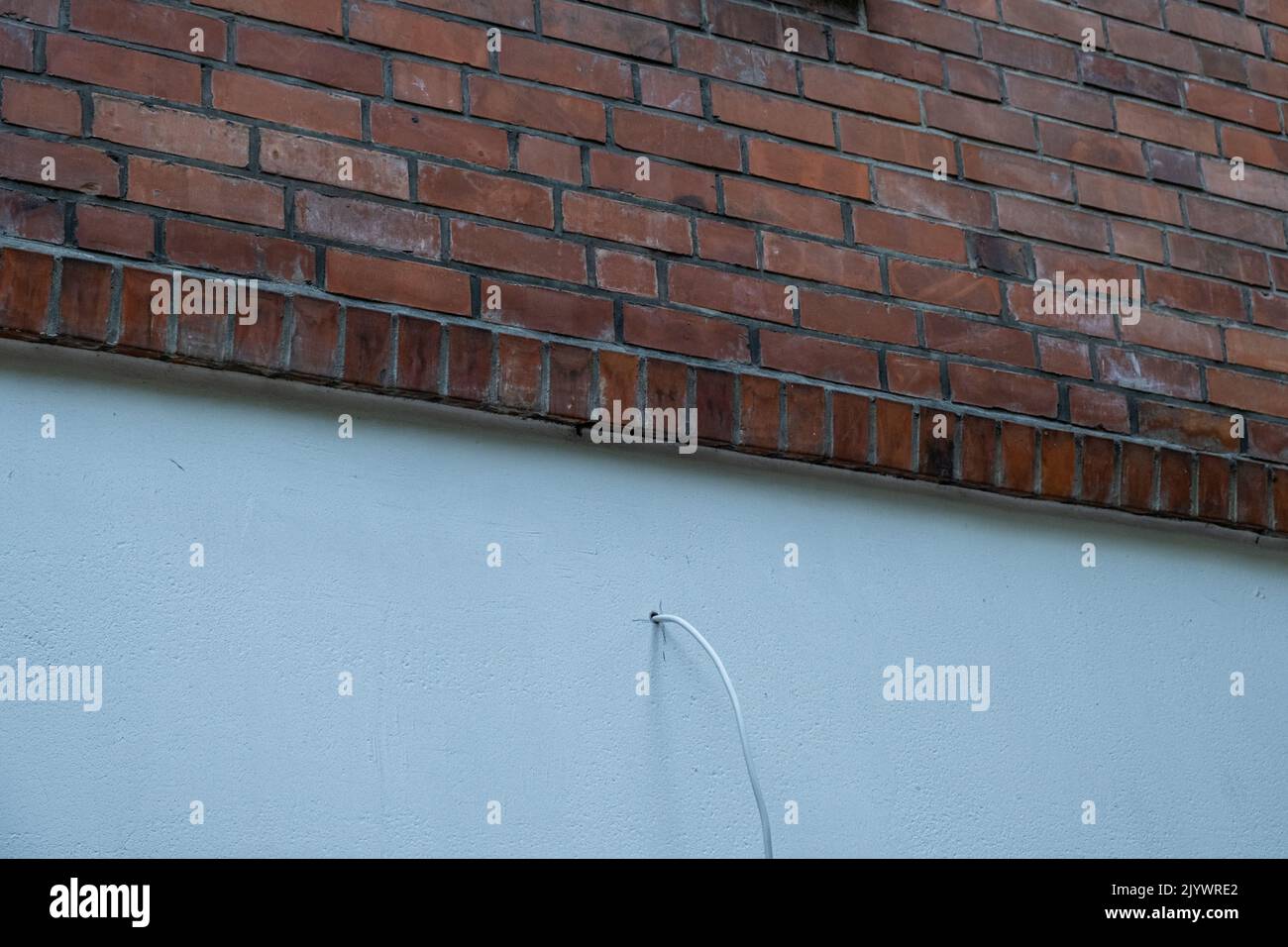 closeup of a new building with red bricks and a white wall with a ...