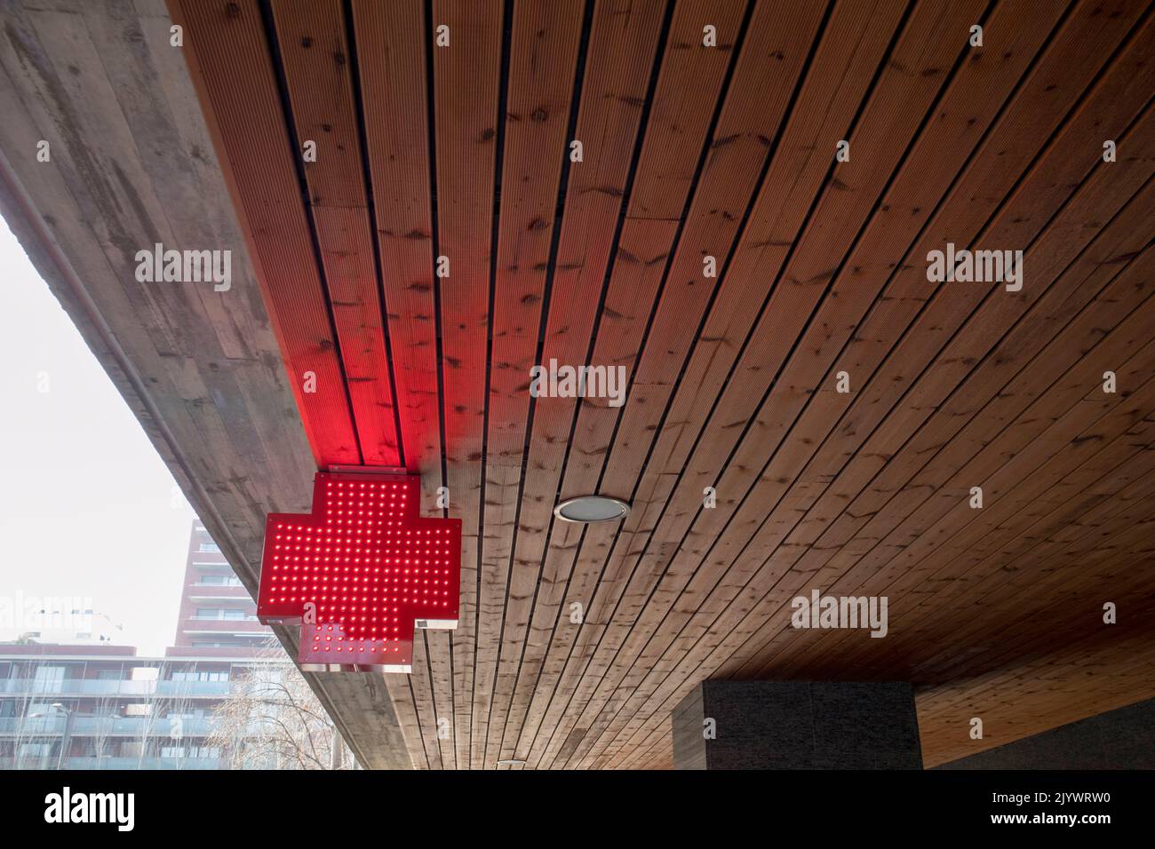 Pharmacy symbol, red illuminated cross hanging Stock Photo - Alamy