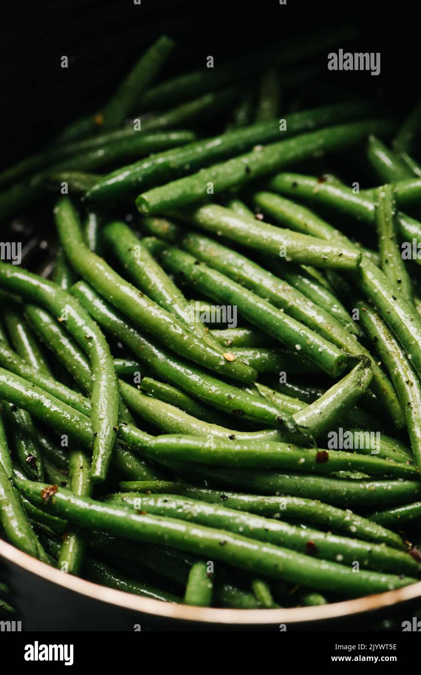 Raw, and seasoned green beans in an air fryer Stock Photo - Alamy