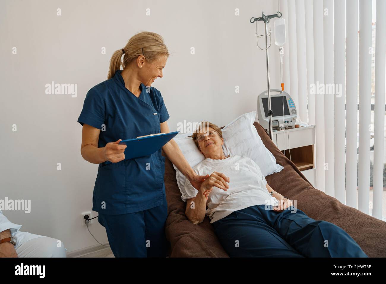 Nurse supporting a sick patient before medical procedures in a hospital ...