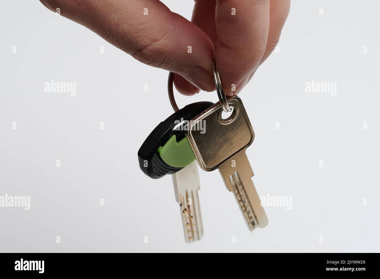 Close up of home keys in hand isolated on studio background Stock Photo ...