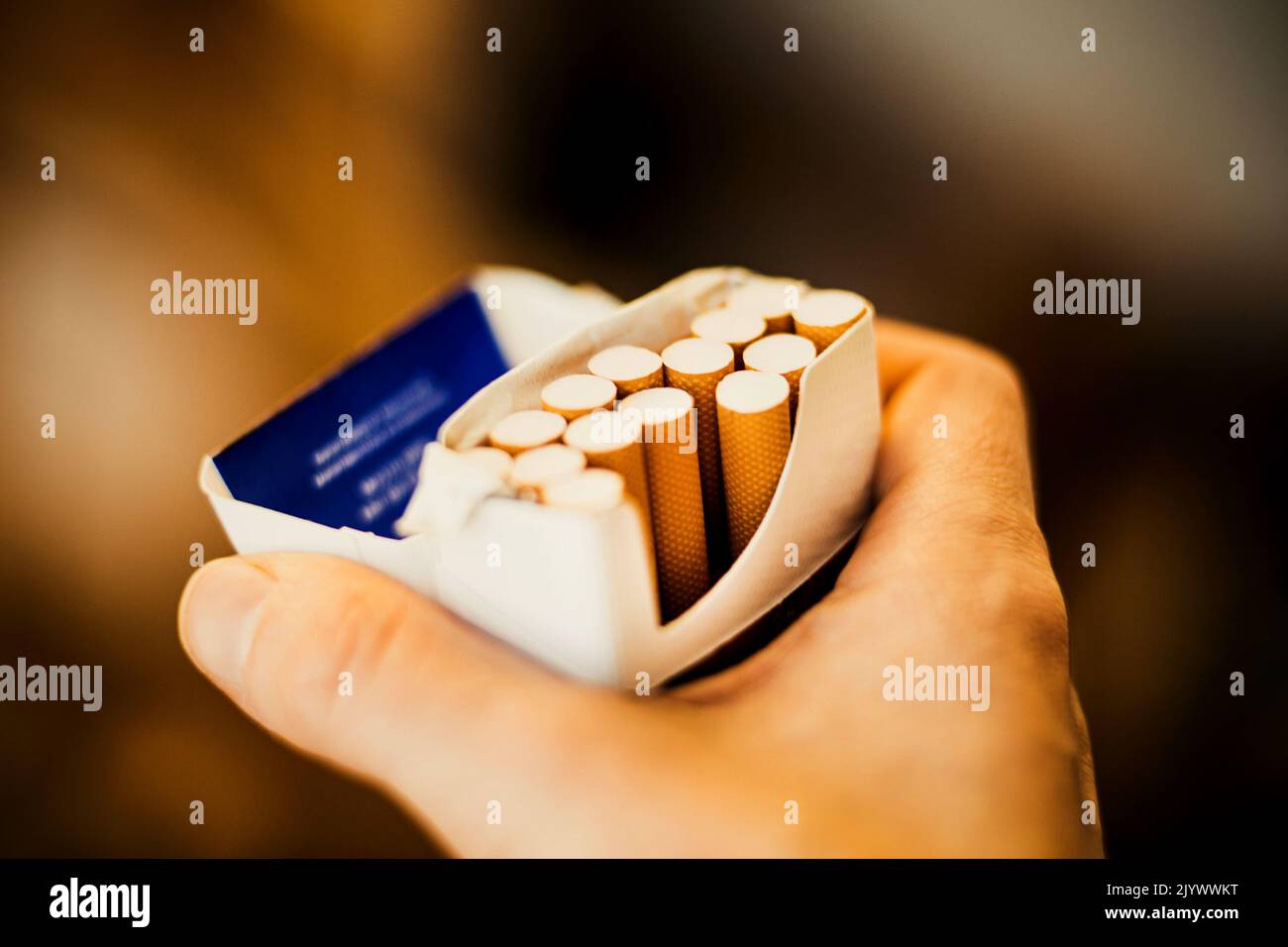 A human holds an open pack of cigarettes in his hand. Smoking kills. A ...