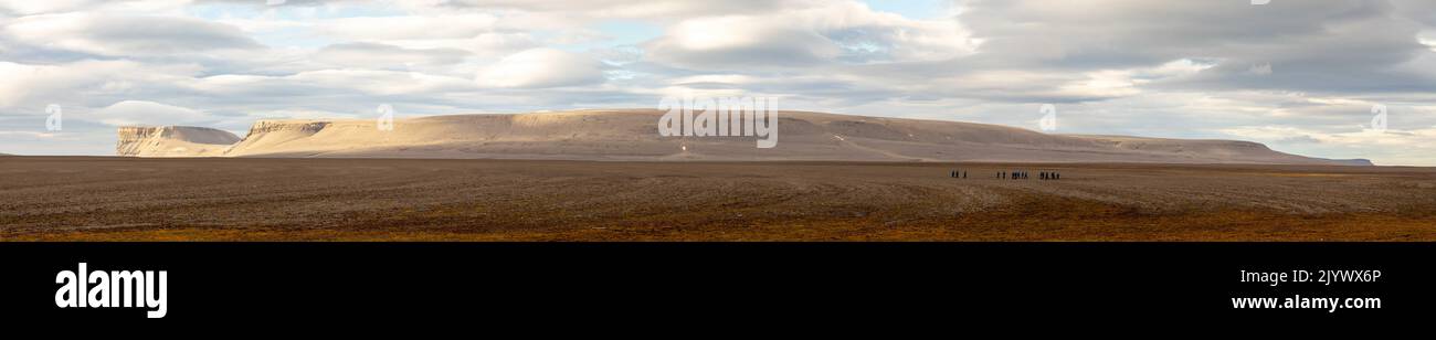 Hikers on tundra at Caswell Tower in Radstock Bay, Devon Island ...