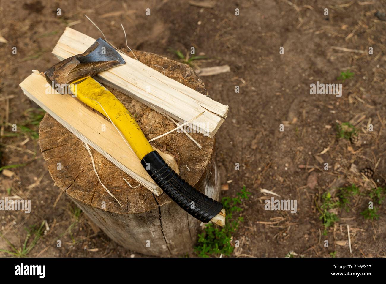 an axe with a plastic handle and a split wooden log on a stump Stock ...