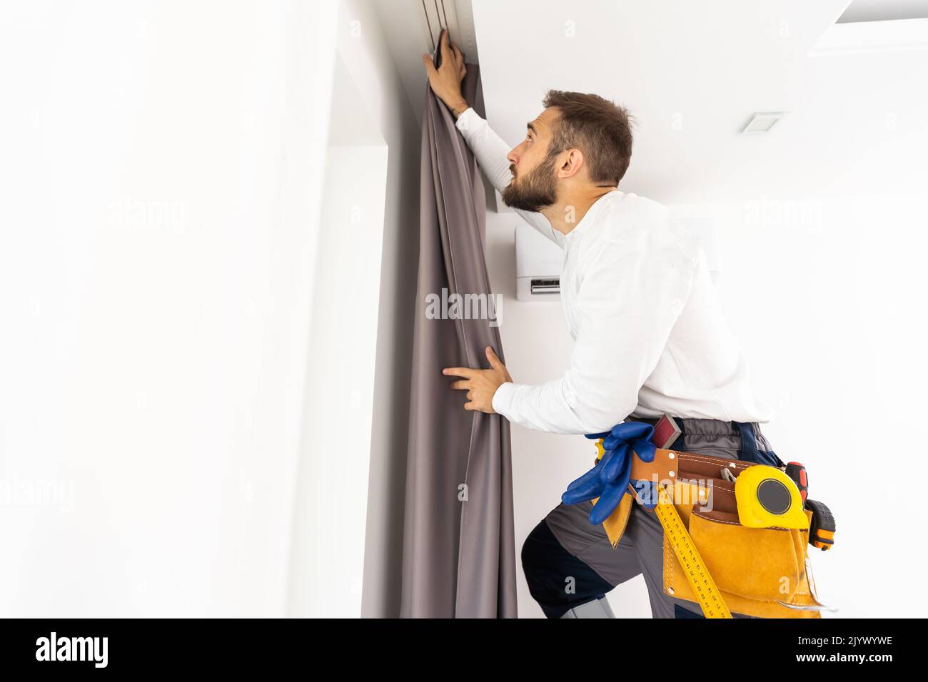 Man hanging curtains hi-res stock photography and images - Alamy