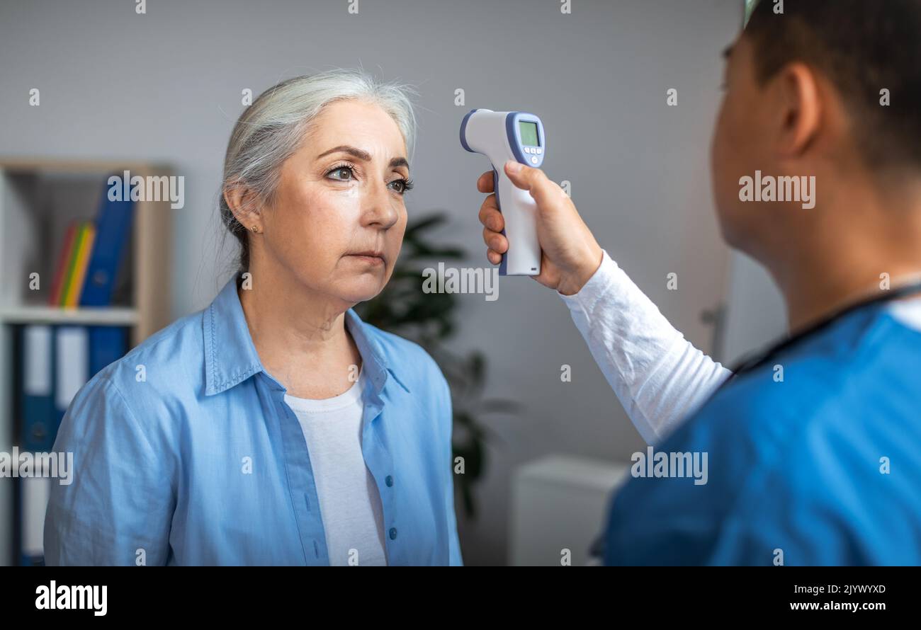Adult asian male doctor checking temperature with contactless ...