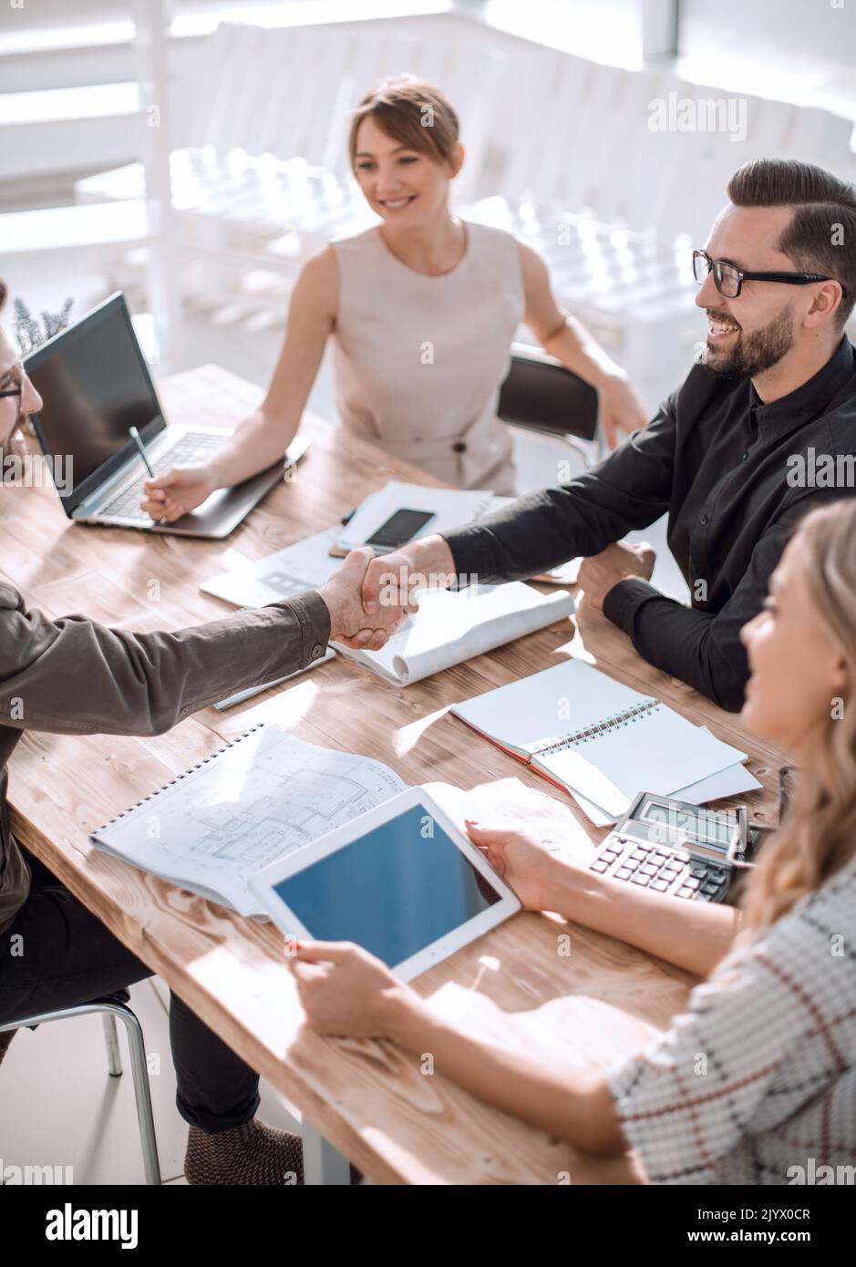 smiling business partners shaking hands at a business meeting Stock ...