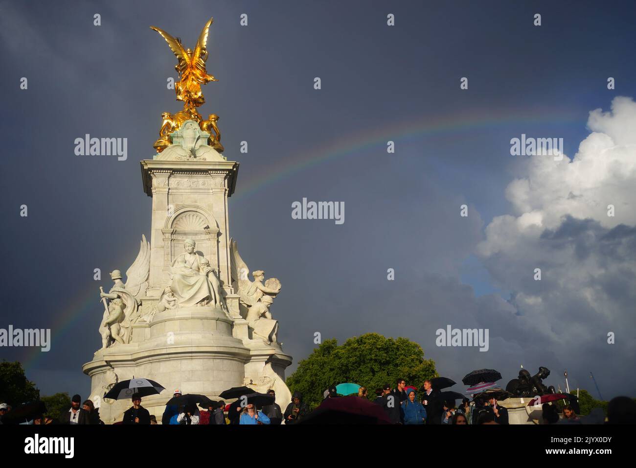 A rainbow over Queen Victoria Memorial, as members of the public gather ...