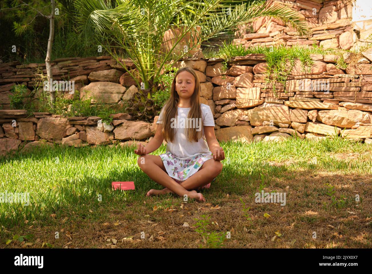 a girl in the garden is sitting in meditation Stock Photo - Alamy