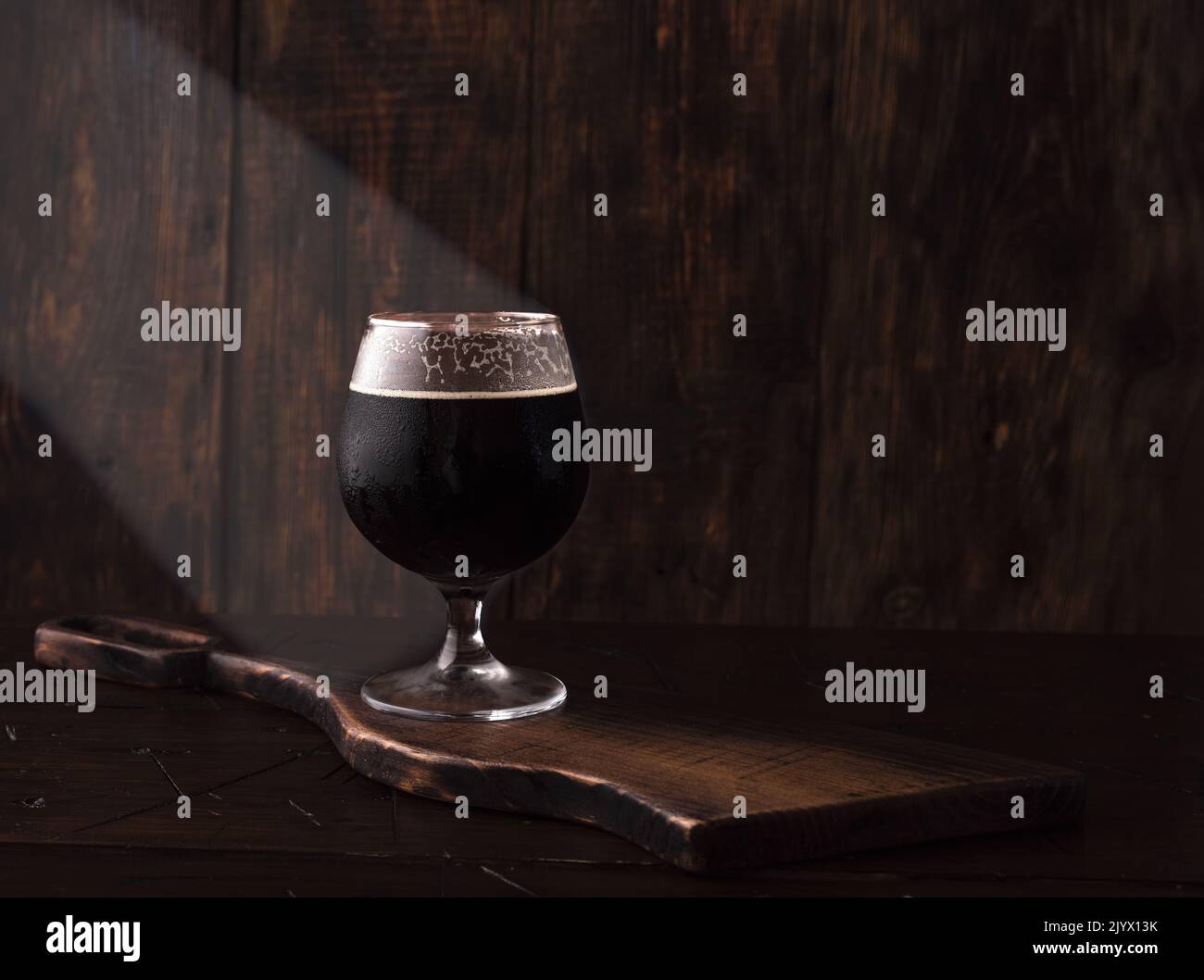 A glass of dark beer. Beer with traces of foam on the glass. Beer on ...