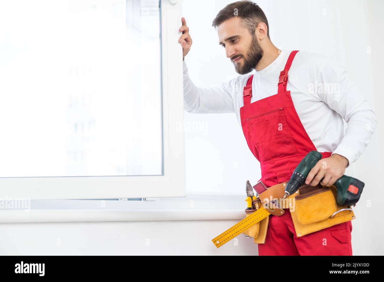 service man installing window with screwdriver Stock Photo - Alamy