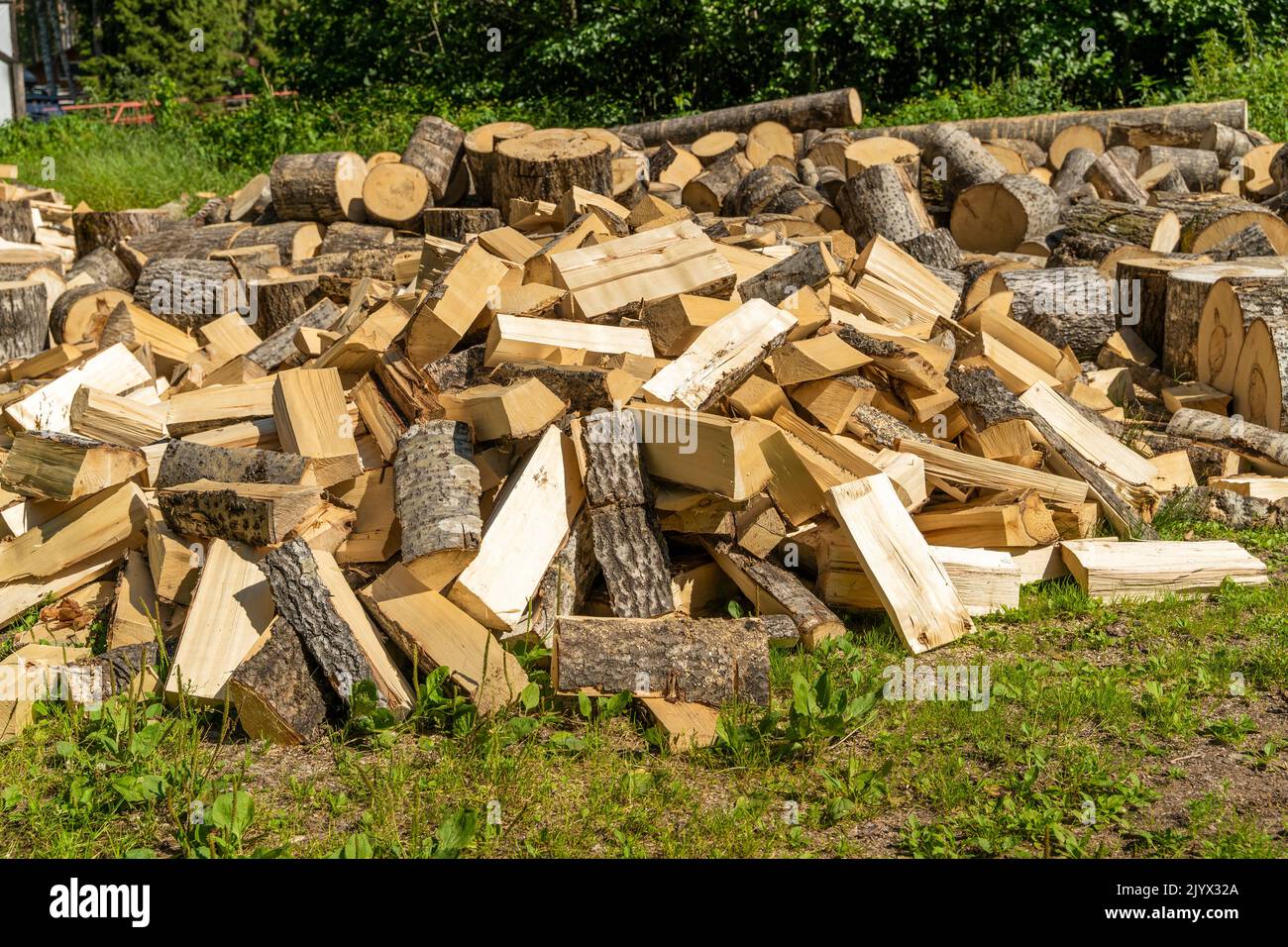 a pile of chopped wood in the yard of the house. preparation for winter ...