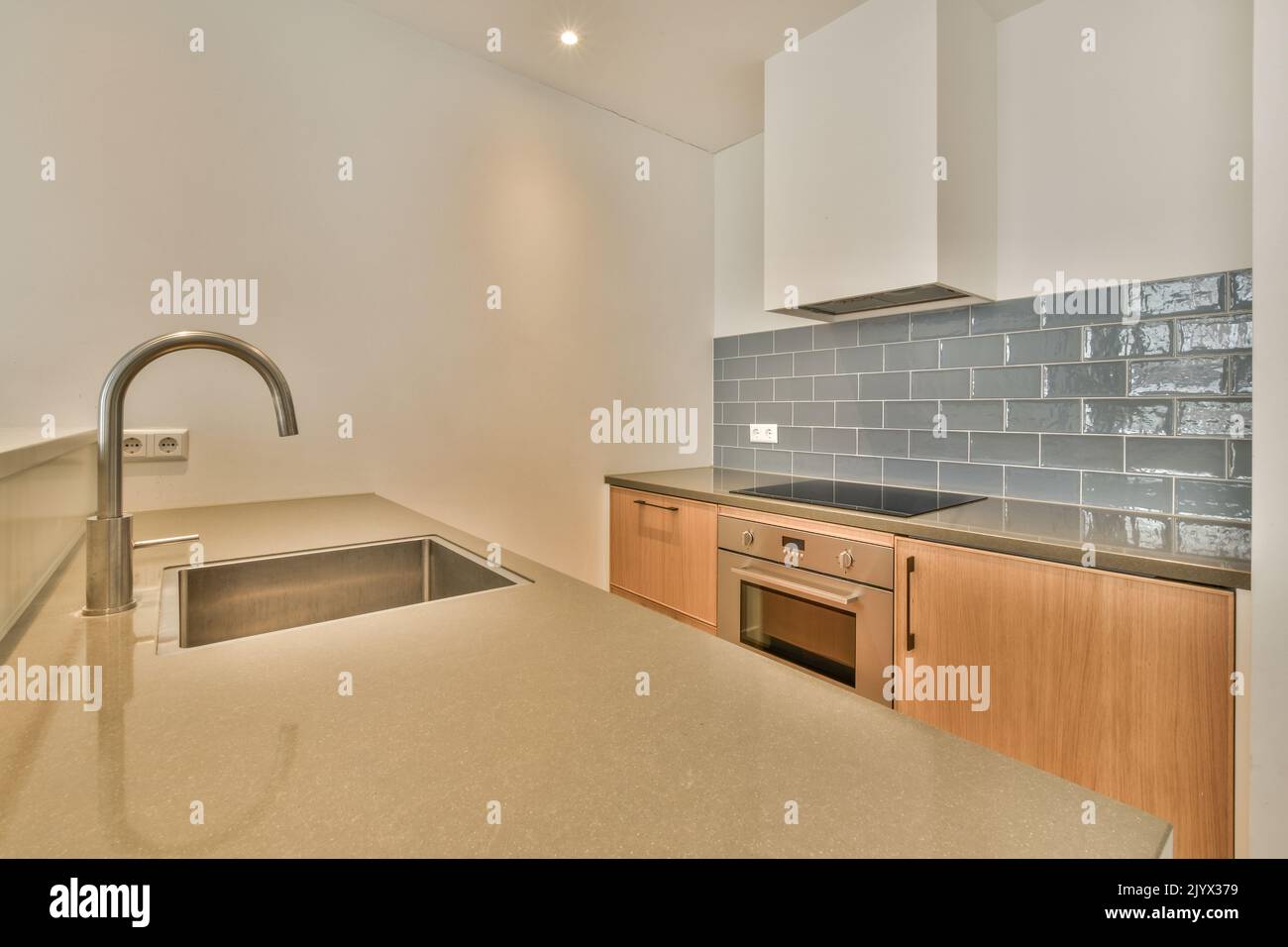 Contemporary counters and stools located under stylish exhaust hood in ...