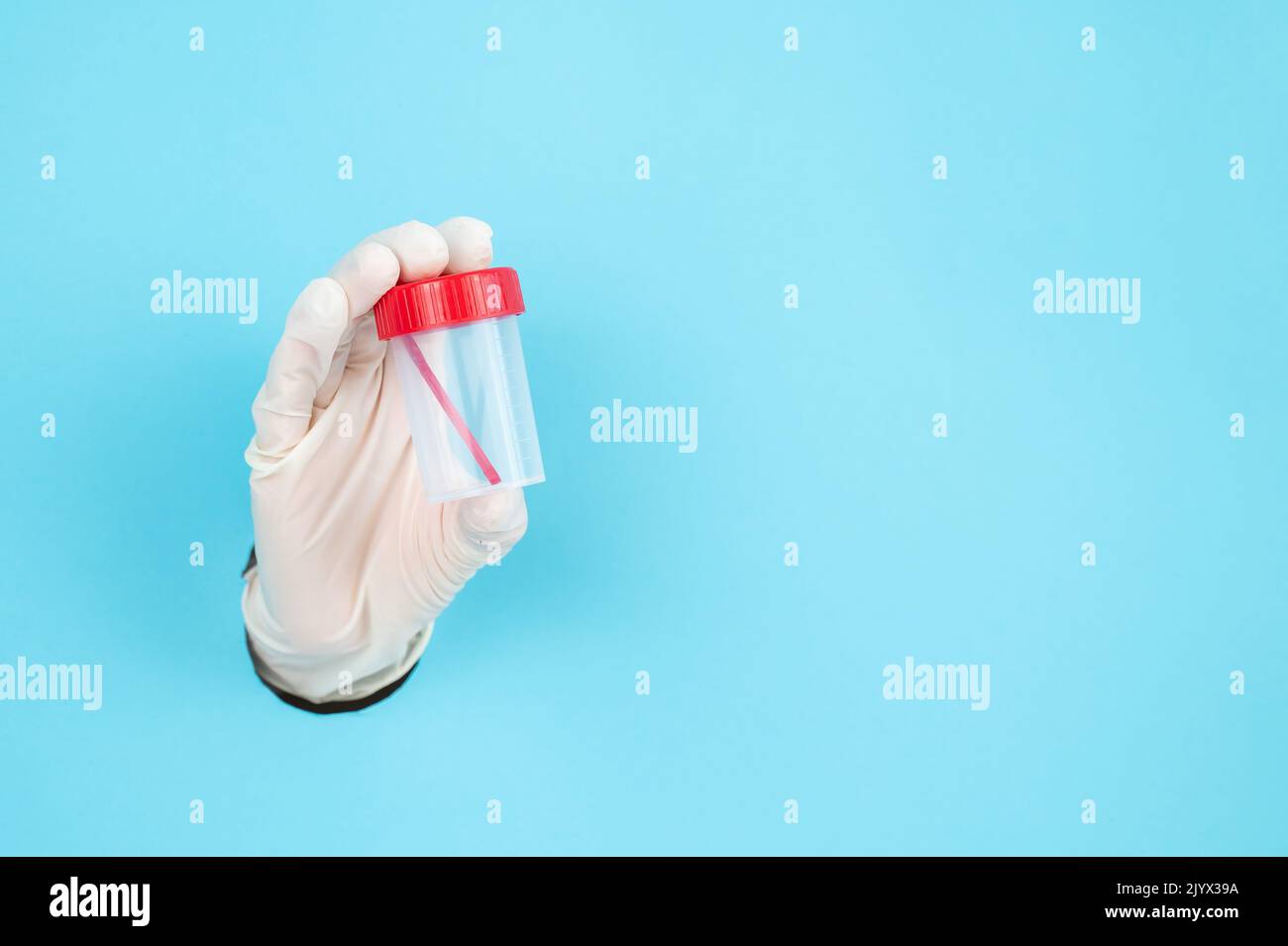A woman's hand in a rubber glove sticks out through a blue paper ...