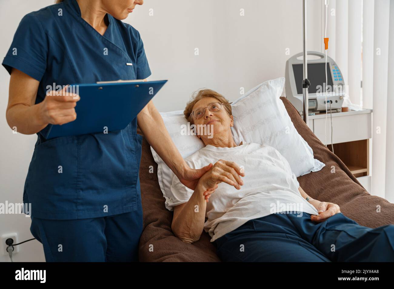 Doctor measures patient's heart rate and makes note during treatment in ...