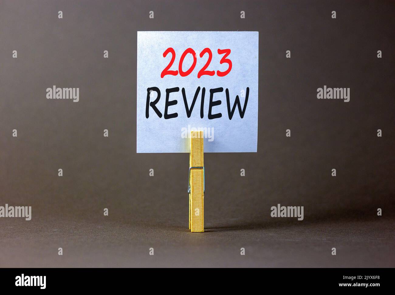 2023 Review symbol. White paper with words 2023 Review, clip on wooden ...