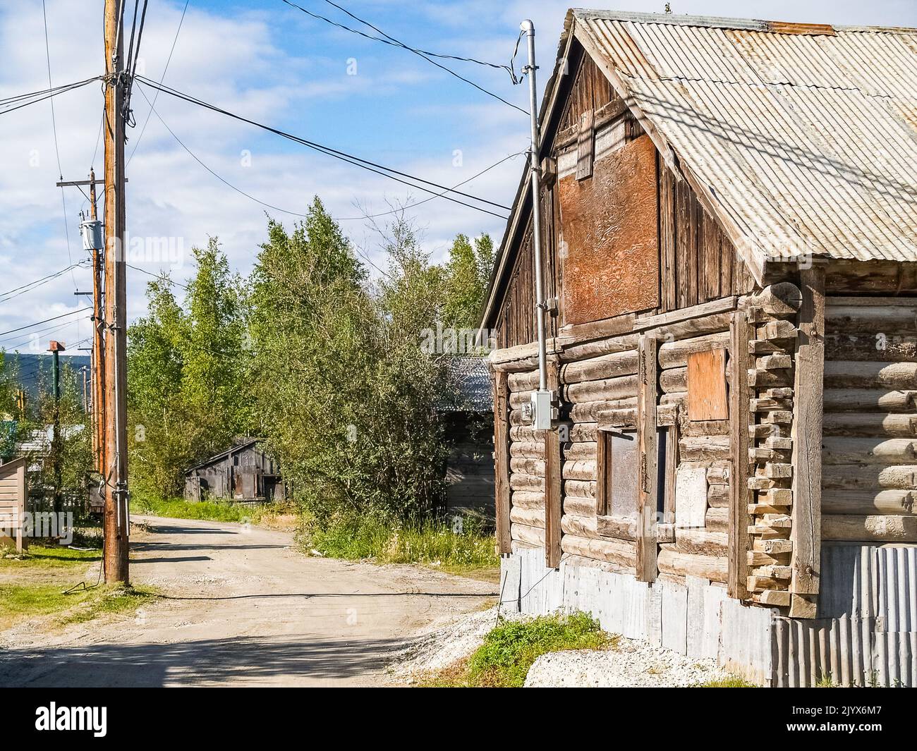 Log cabin style building in dusty town street in historic mining Yukon ...