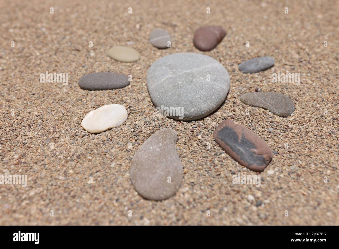 Figure of sun is made of pebble stones on sandy beach in summer Stock ...