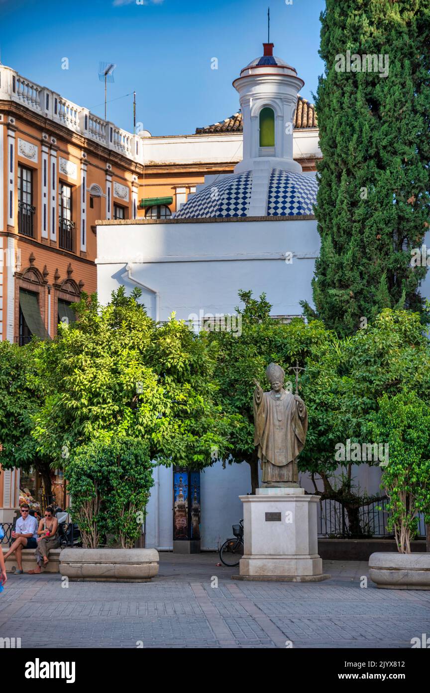 Statue of a robed figure surrounded by trees in a quiet square in ...