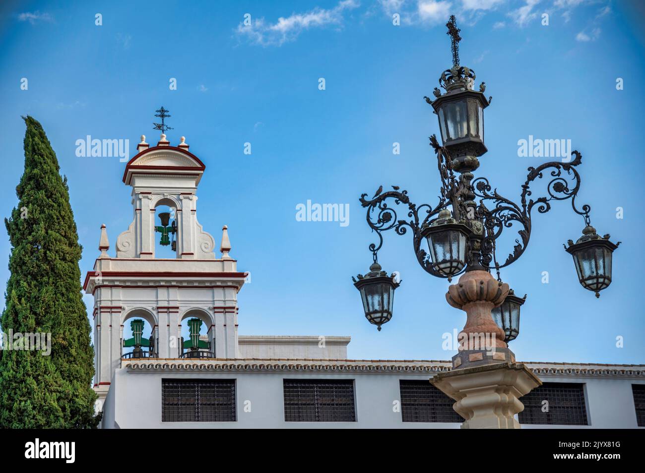 Traditional bell tower and ornate street lanterns in Seville, Spain ...