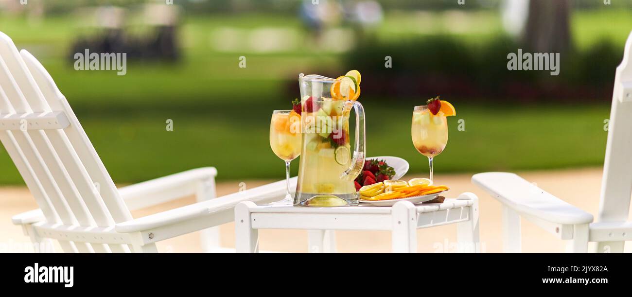 Lemonade in glass pitcher with slice oranges, and limes. Topped with ...