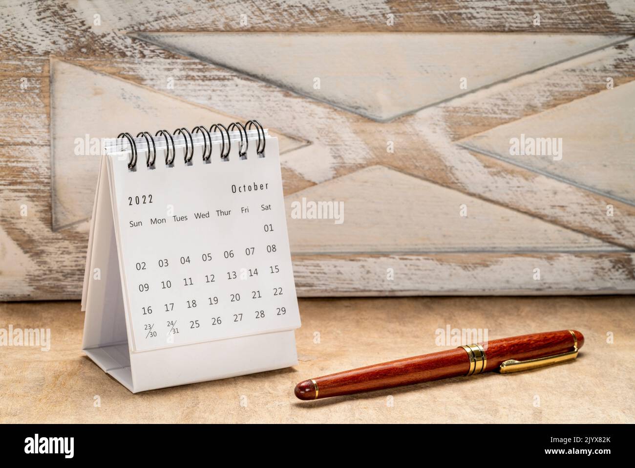 October 2022 - small desktop calendar against rustic wood, time and ...