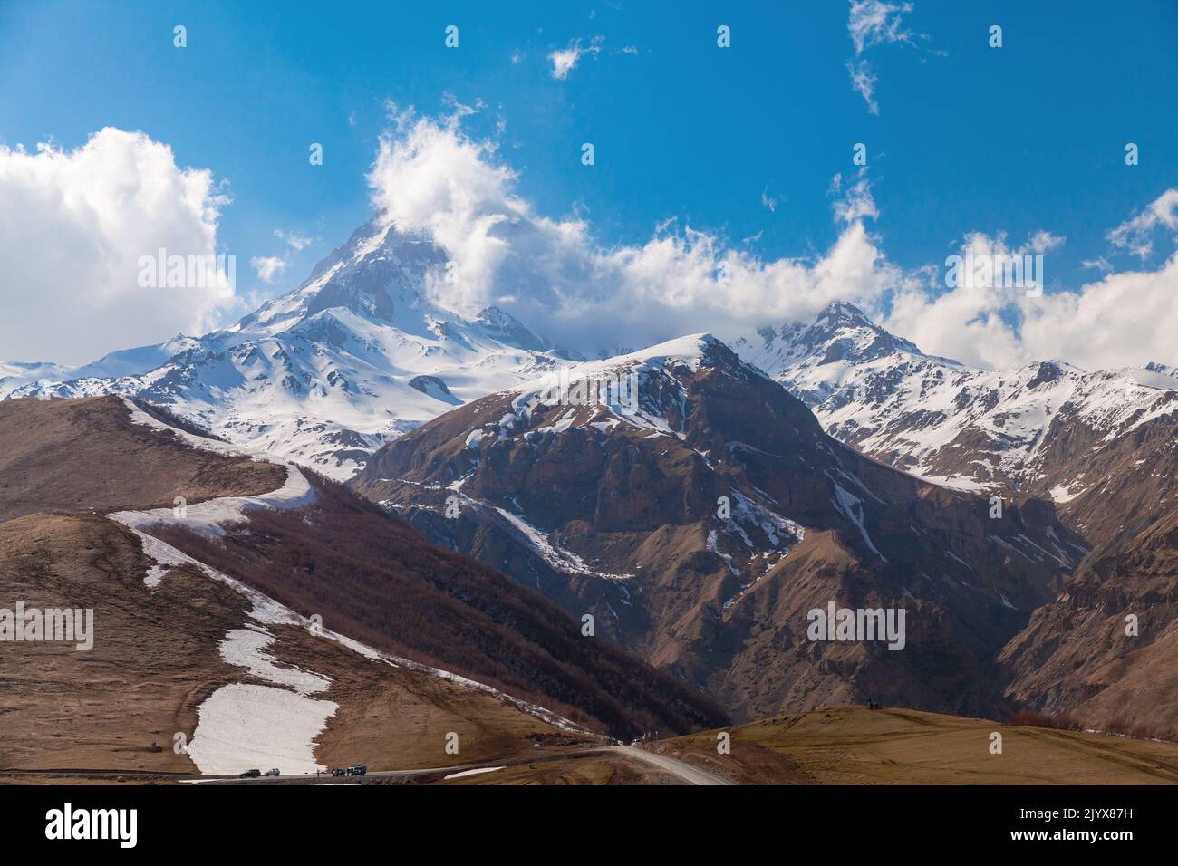 Georgian landscape with mountain road and Mount Kazbek on a sunny day ...