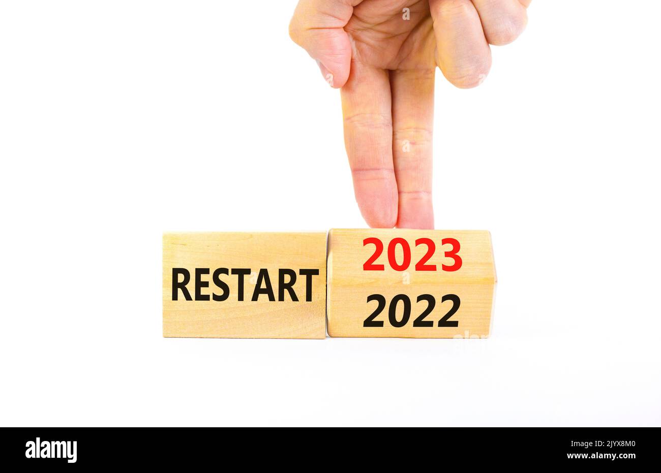 2023 restart new year symbol. Businessman turns a wooden cube and ...