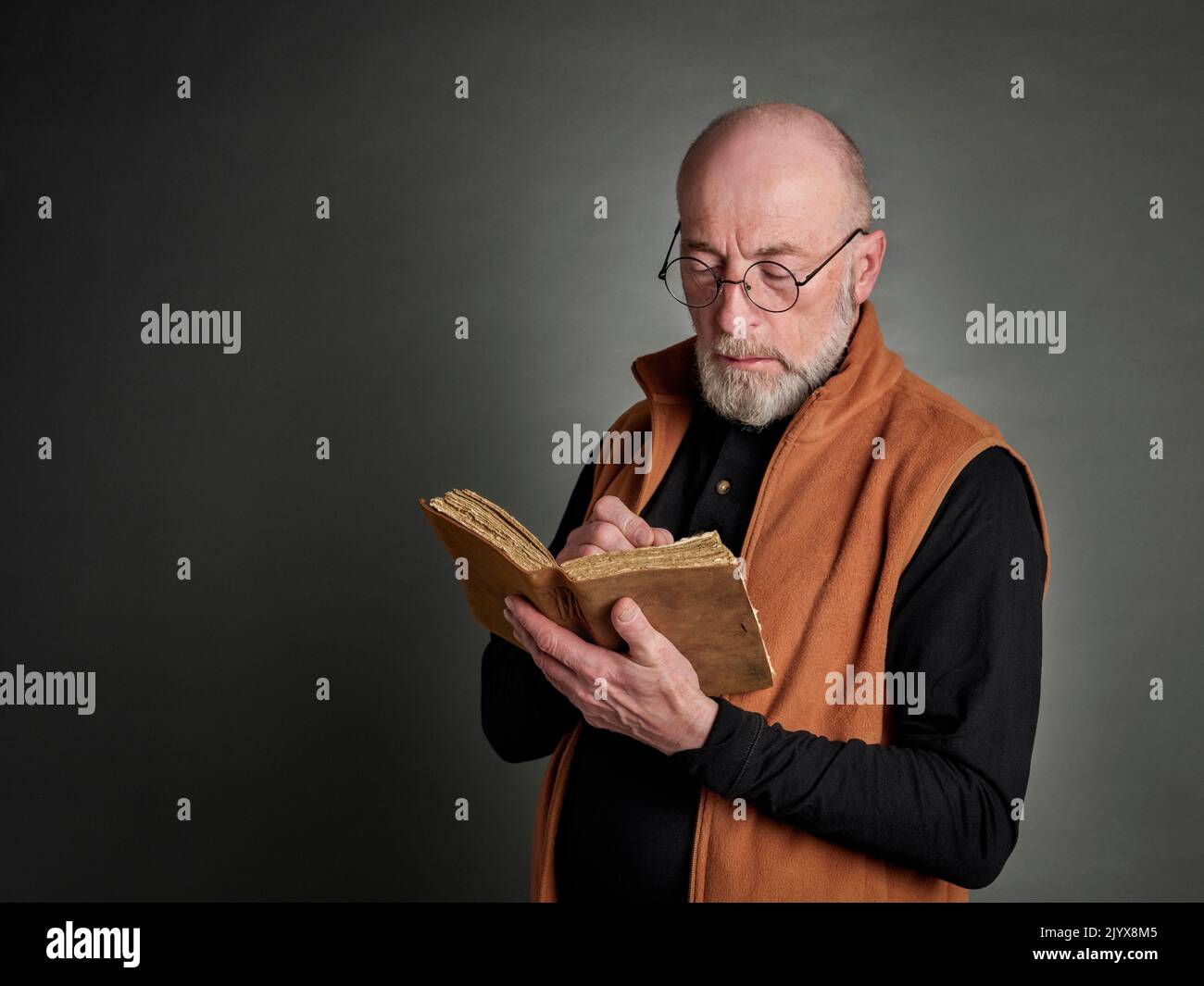 Head and shoulders portrait of bald and bearded senior man writing a ...