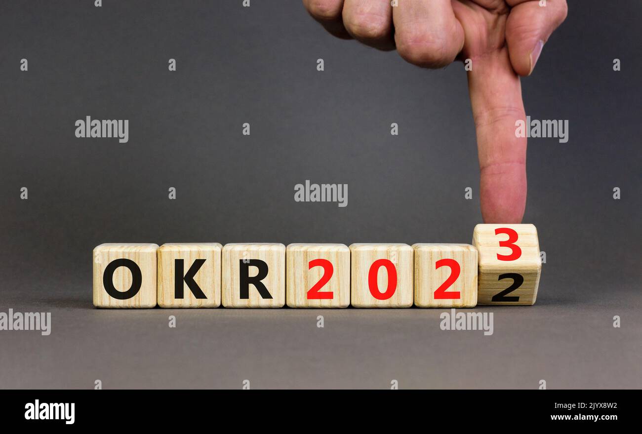 OKR, objectives and key results symbol. Businessman turns cubes with words OKR 2022 and OKR 2023 ...