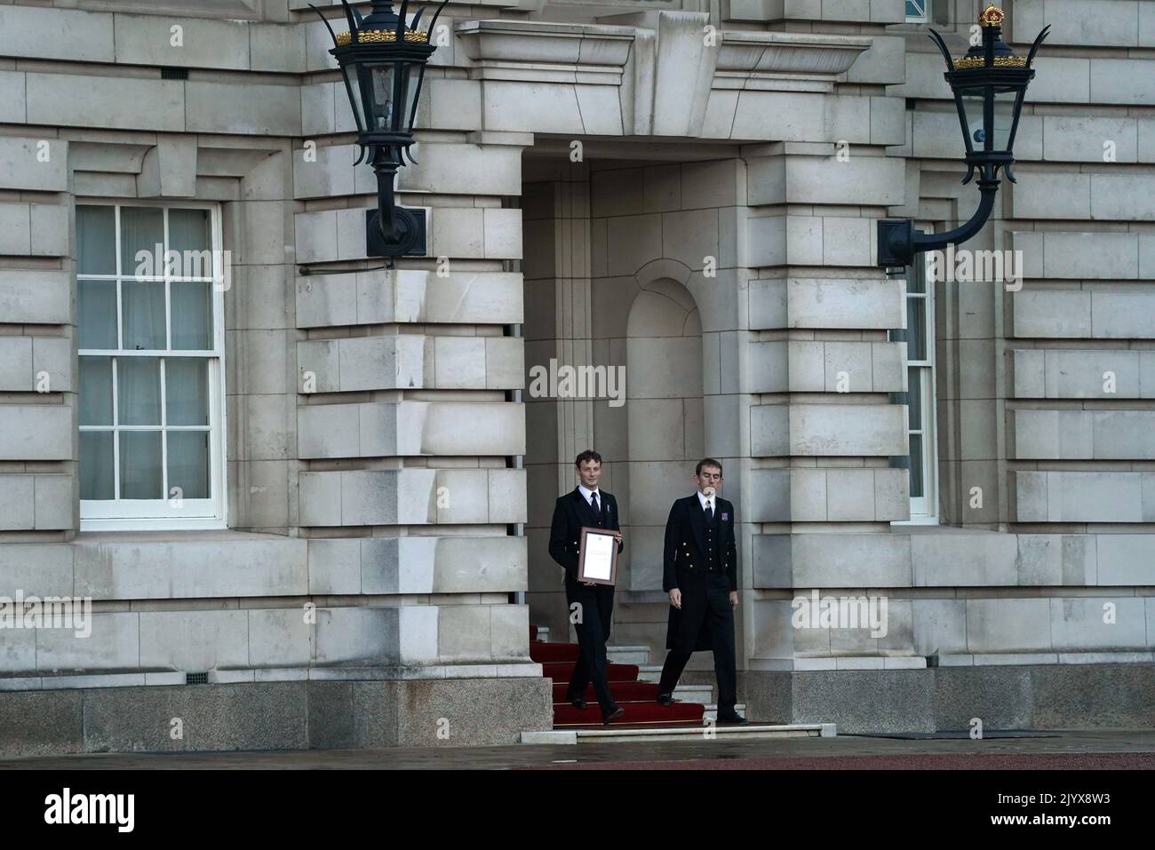 A member of royal household staff posts a notice on the gates of the ...